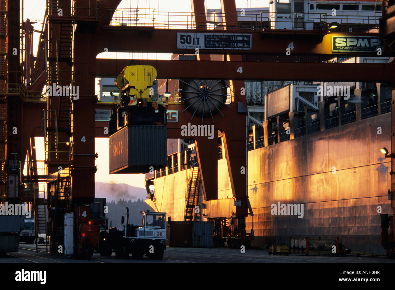 Terminal, Dock crane unloading a container ship at dusk, Port of Vancouver, British Columbia ...