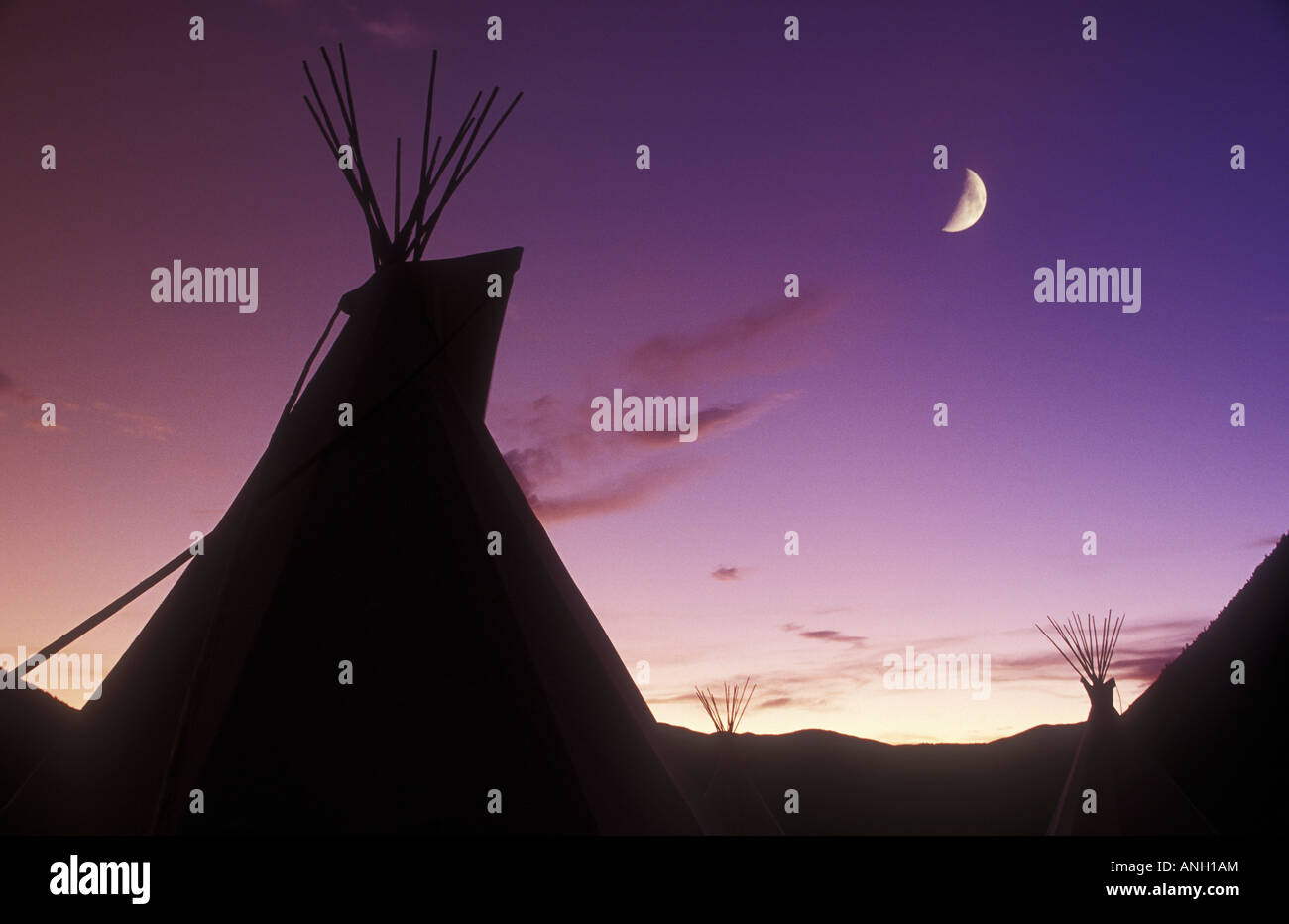 First Nations tee-pee village above the Fraser River at twilight with ...