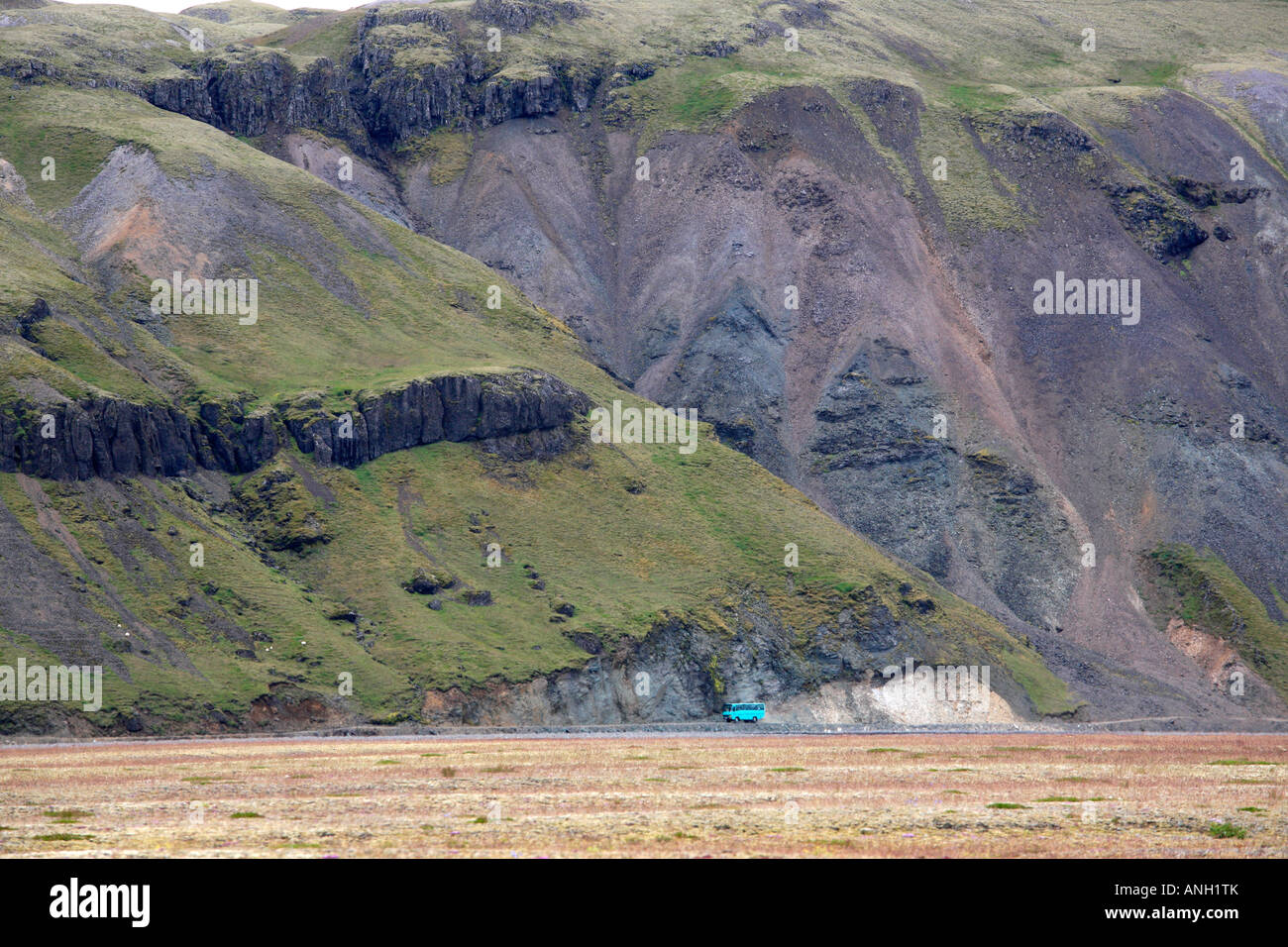 turquoise bus in front of blue and violet coloured mountains Lónsöraefi ...