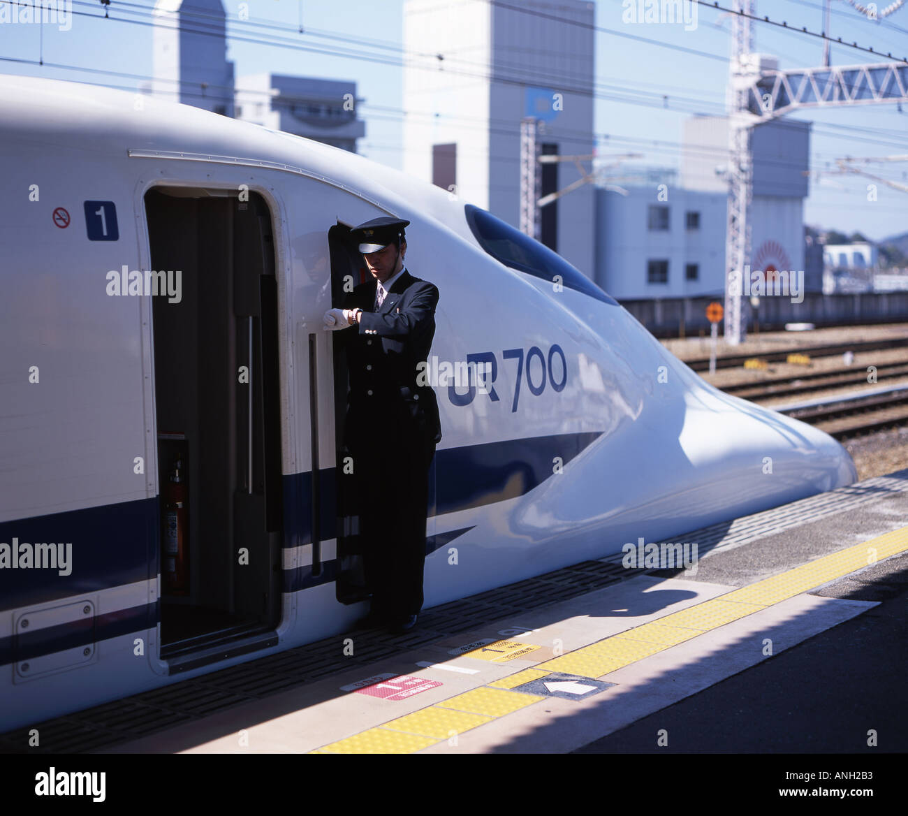 Bullet train conductor checks his watch at the station Himeji Japan ...