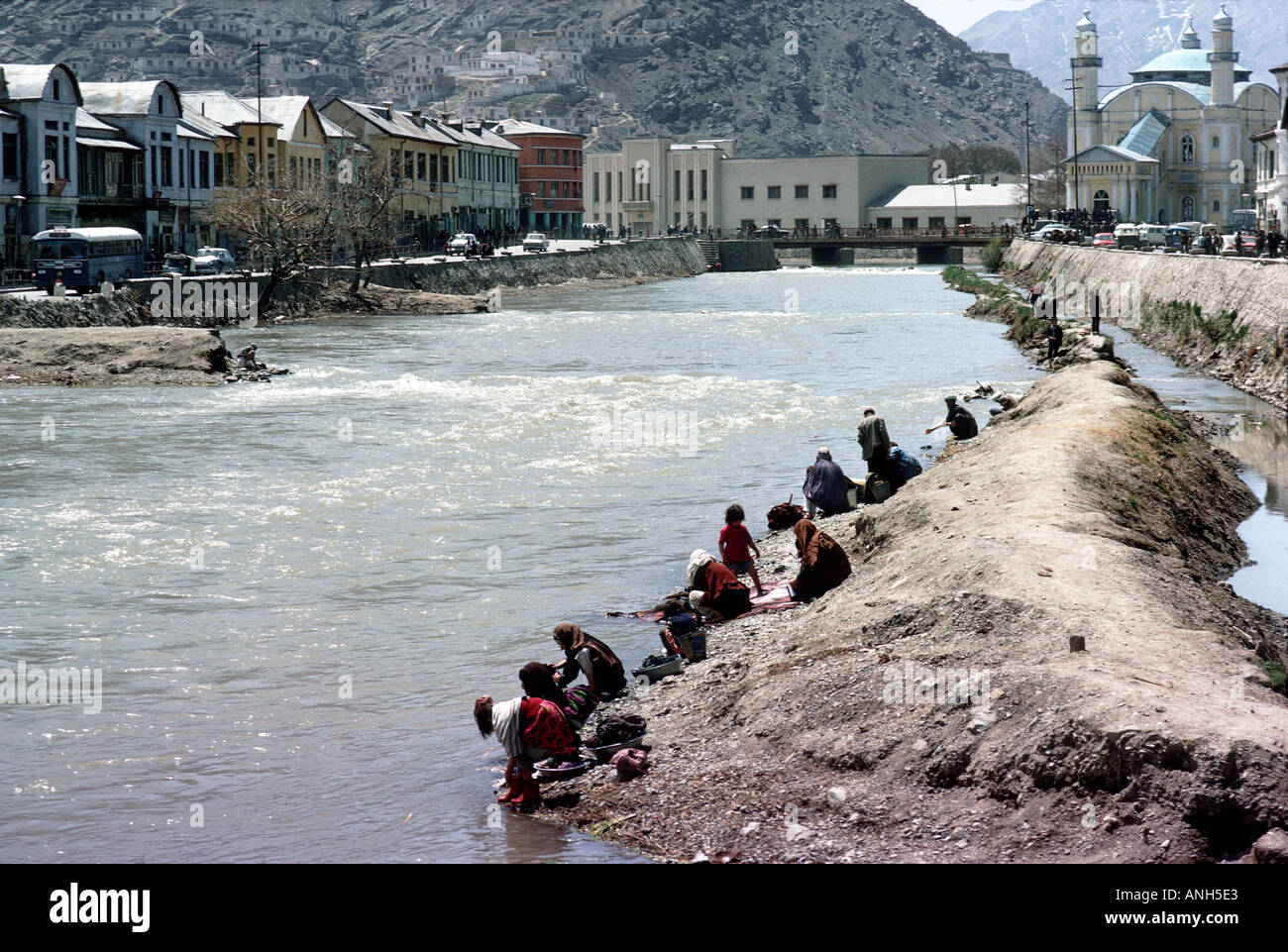 Kabul City River in full flow with people doing their daily ablutions ...