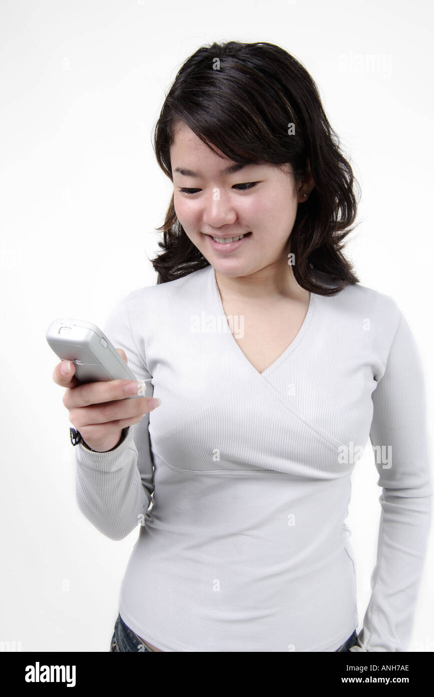 Asian girl on the phone sending a text message Stock Photo - Alamy
