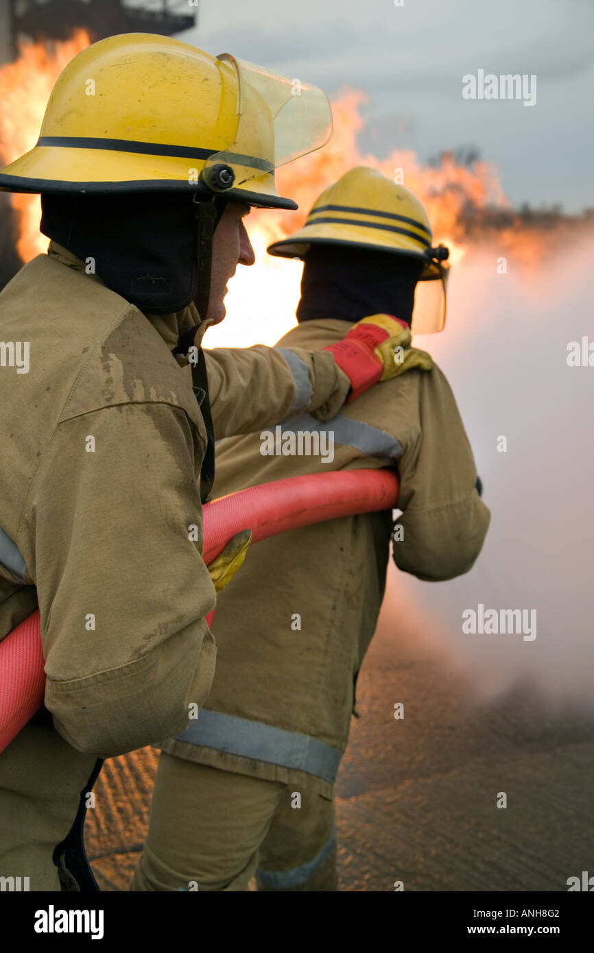 Planned teamwork fire fighting practice Stock Photo - Alamy
