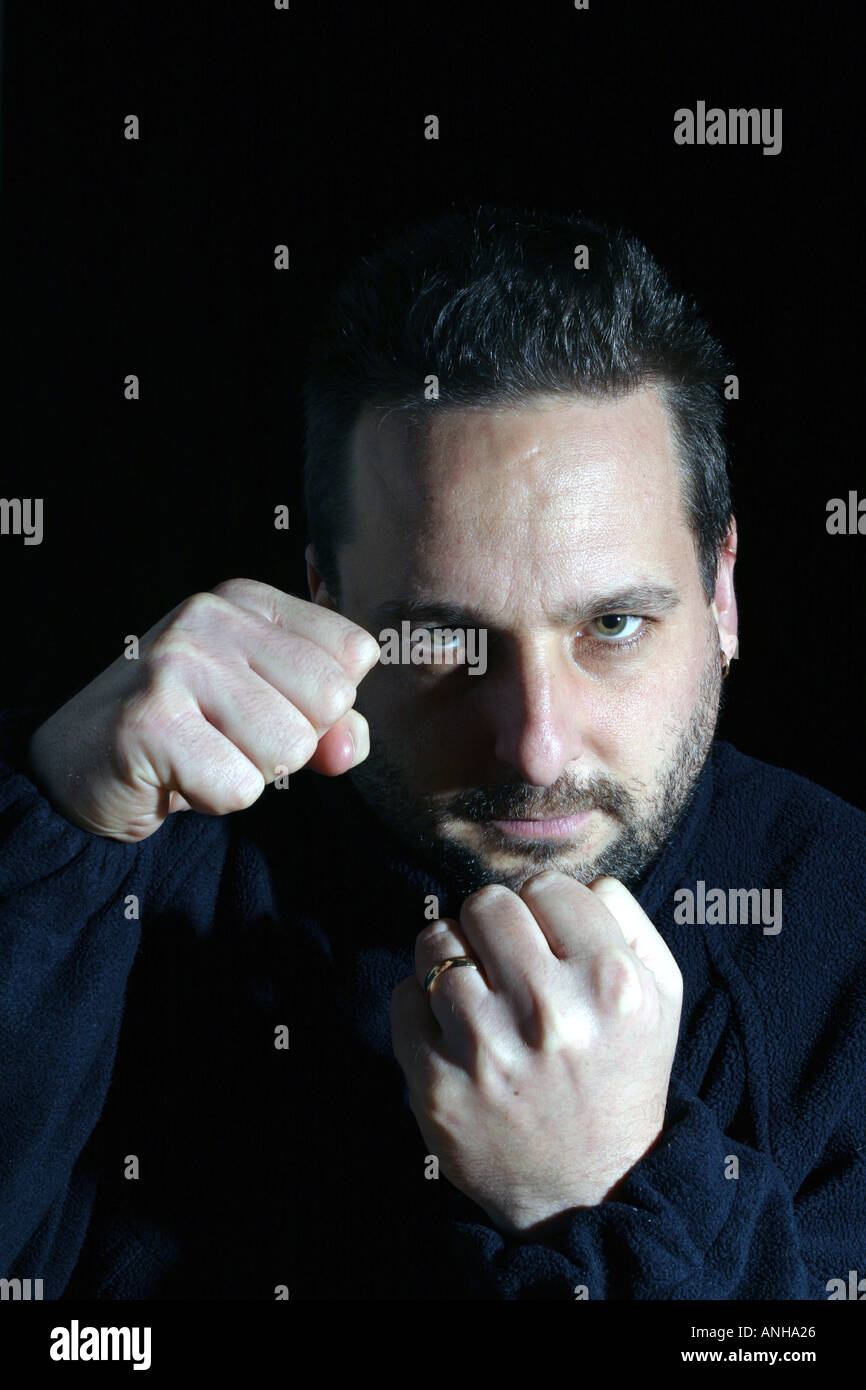 Man holds his fists up in an aggressive pose Stock Photo - Alamy