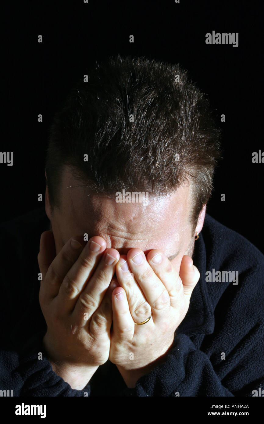 Man with hands covering face Stock Photo - Alamy