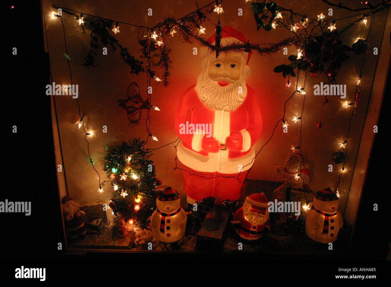 Illuminated Father Christmas doll and fairy lights Stock Photo - Alamy