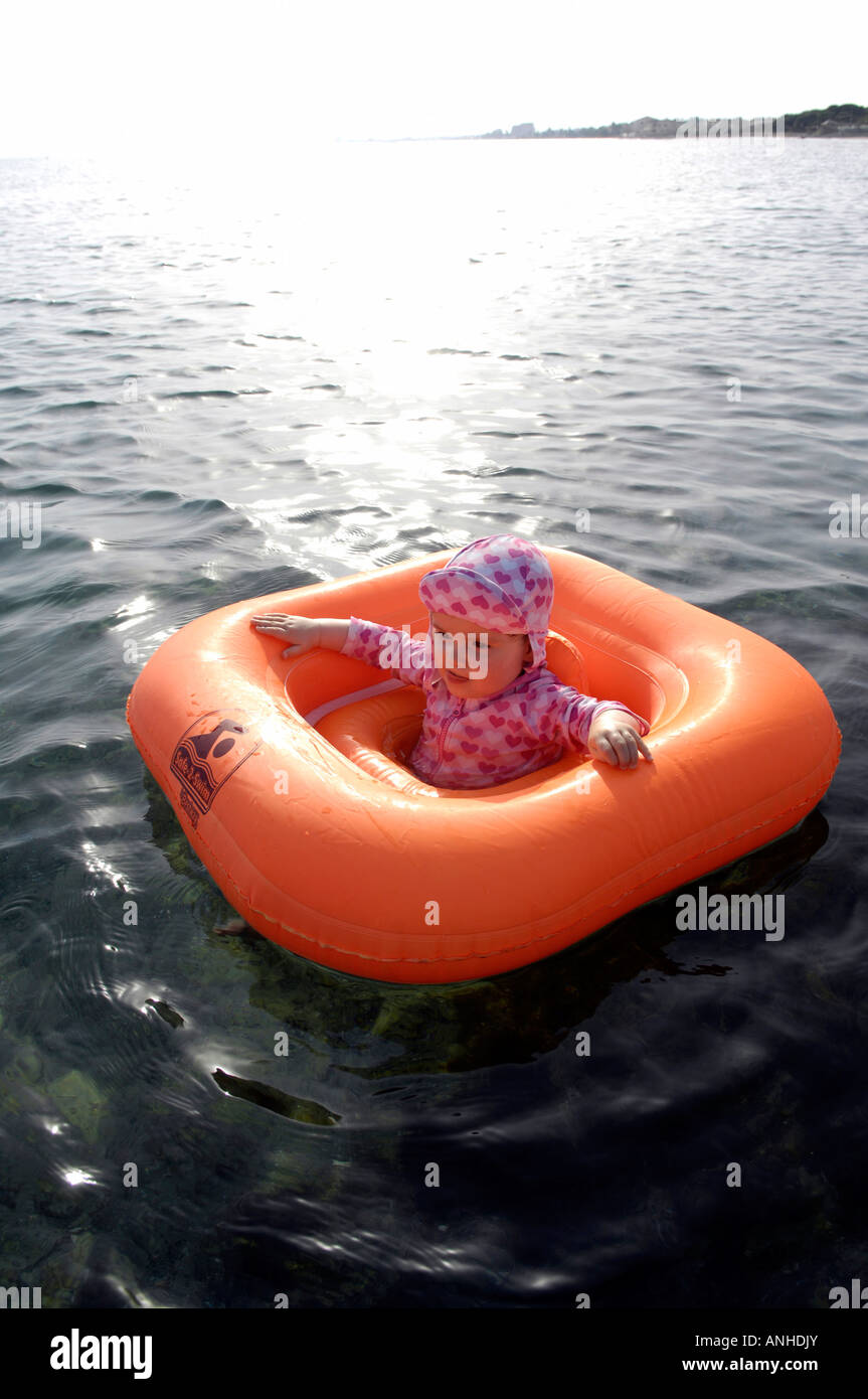 baby girl orange life preserver rubber ring sea ocean travel tourism ...