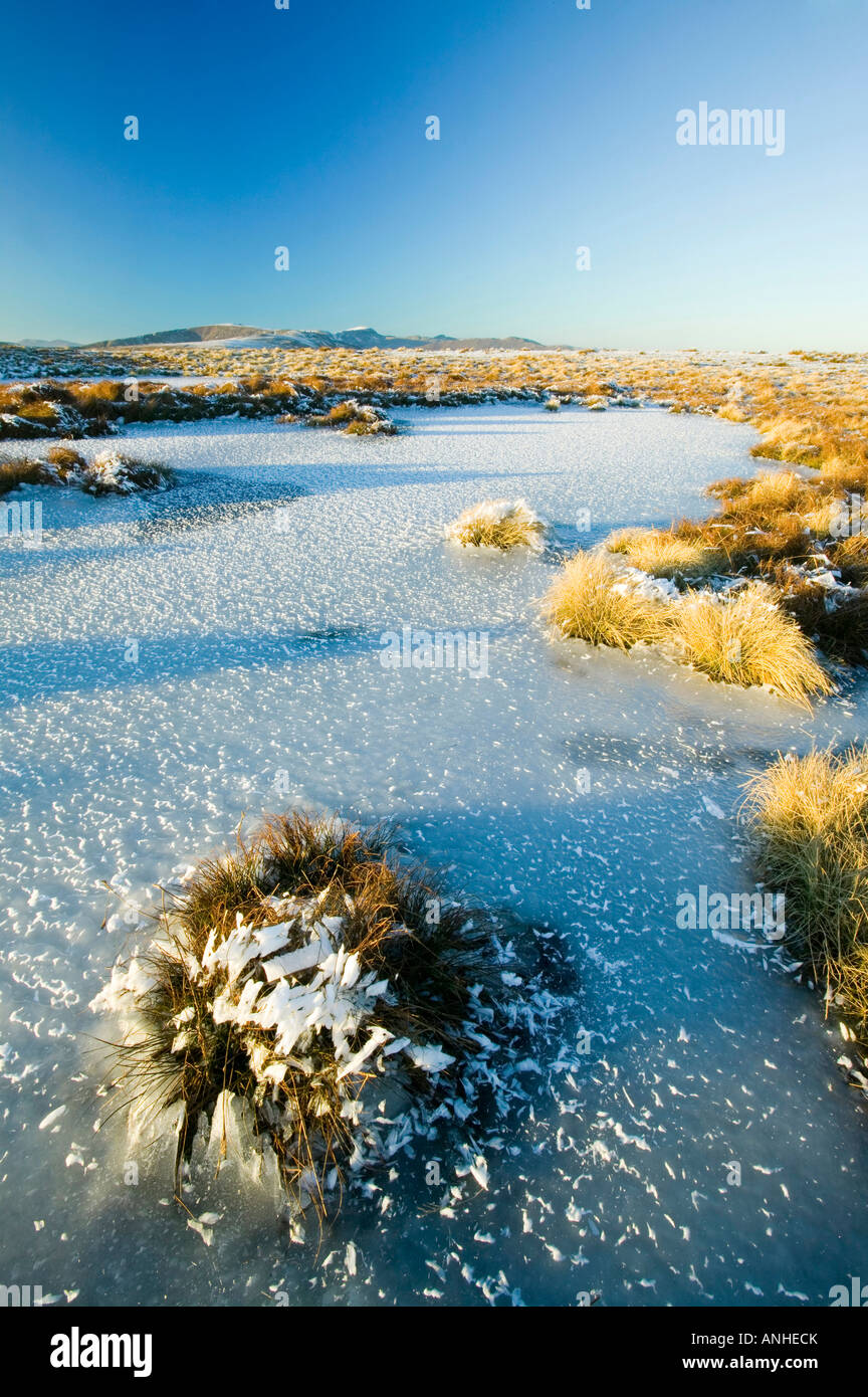 A frozen tarn on the summit of Red Screes in the Lake district National ...