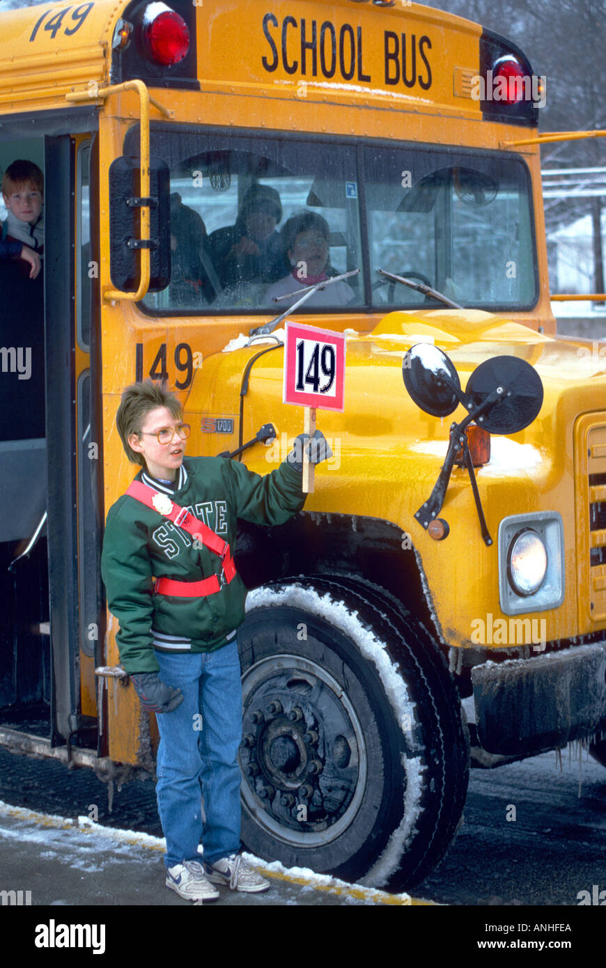 Elementary patrol boy supervises the boarding of a school bus by ...