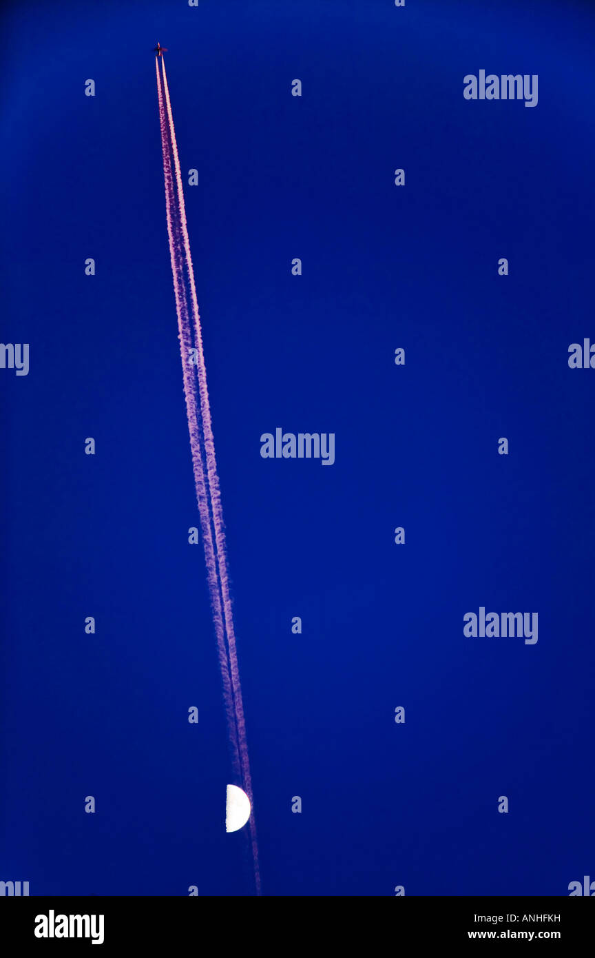 a jet plane flying past the moon at sunset Stock Photo - Alamy