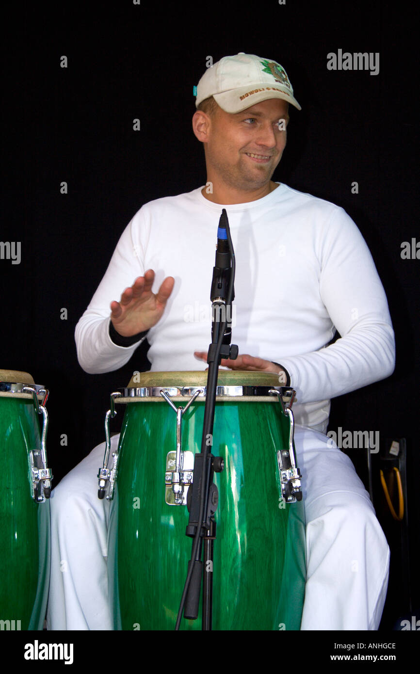 Percussion player dressed in white clothes playing green congas Stock ...