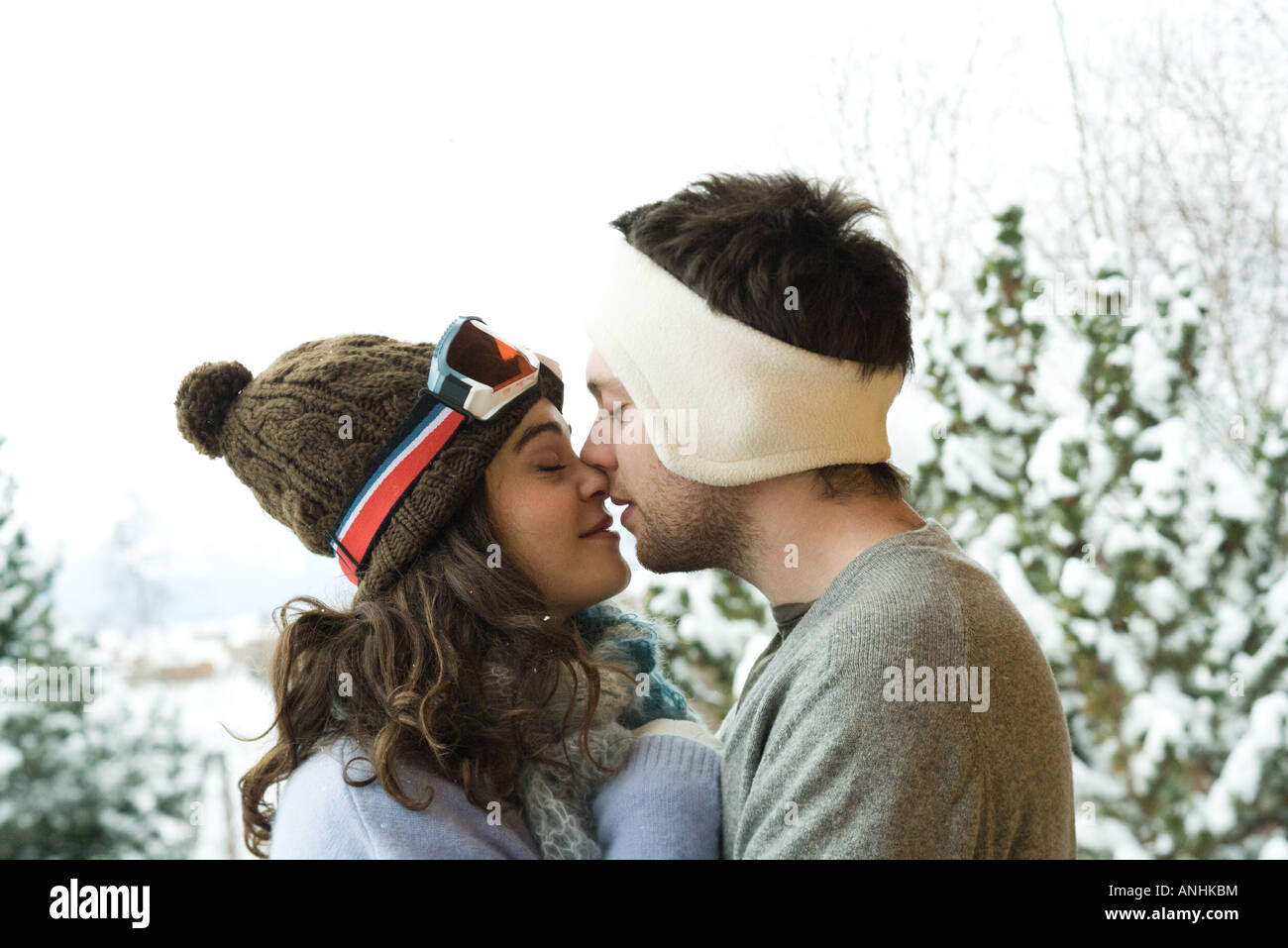 Young couple in winter clothes, kissing, side view Stock Photo - Alamy