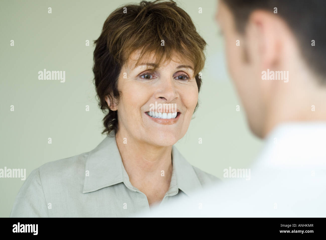 Woman smiling at man, viewed over man's shoulder Stock Photo - Alamy
