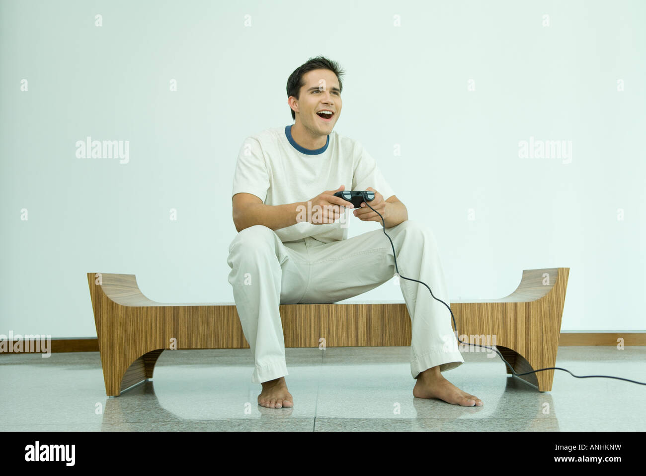 Young man playing video game, smiling Stock Photo - Alamy