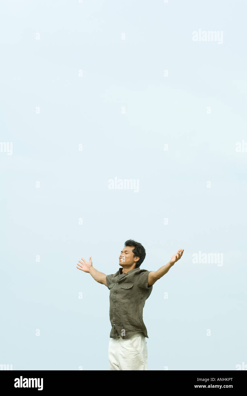 Man standing outdoors with eyes closed, arms out, smiling Stock Photo ...
