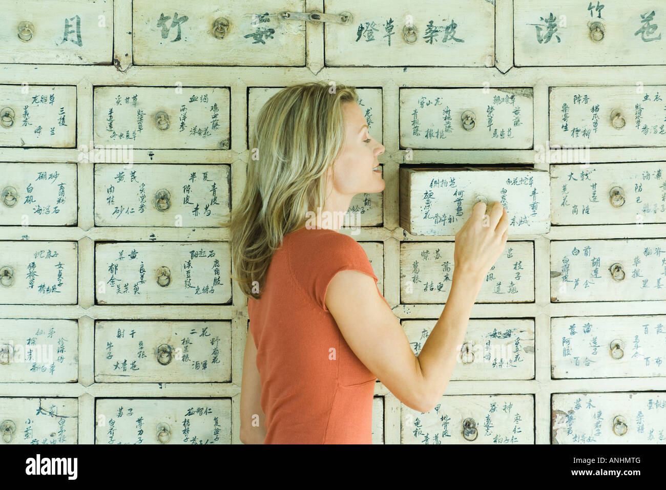 Woman opening drawer in piece of furniture Stock Photo - Alamy