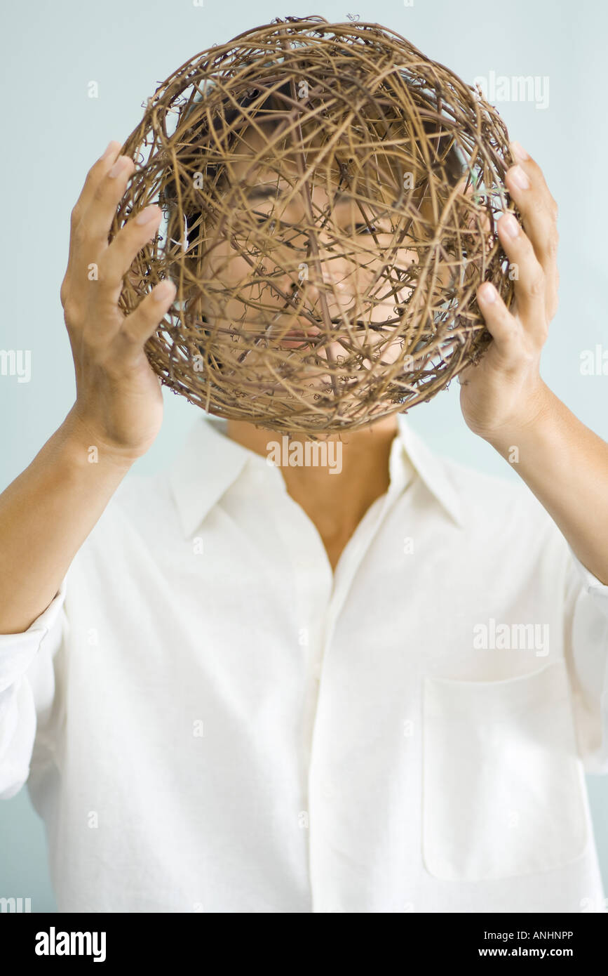 Man holding sphere in front of face Stock Photo - Alamy