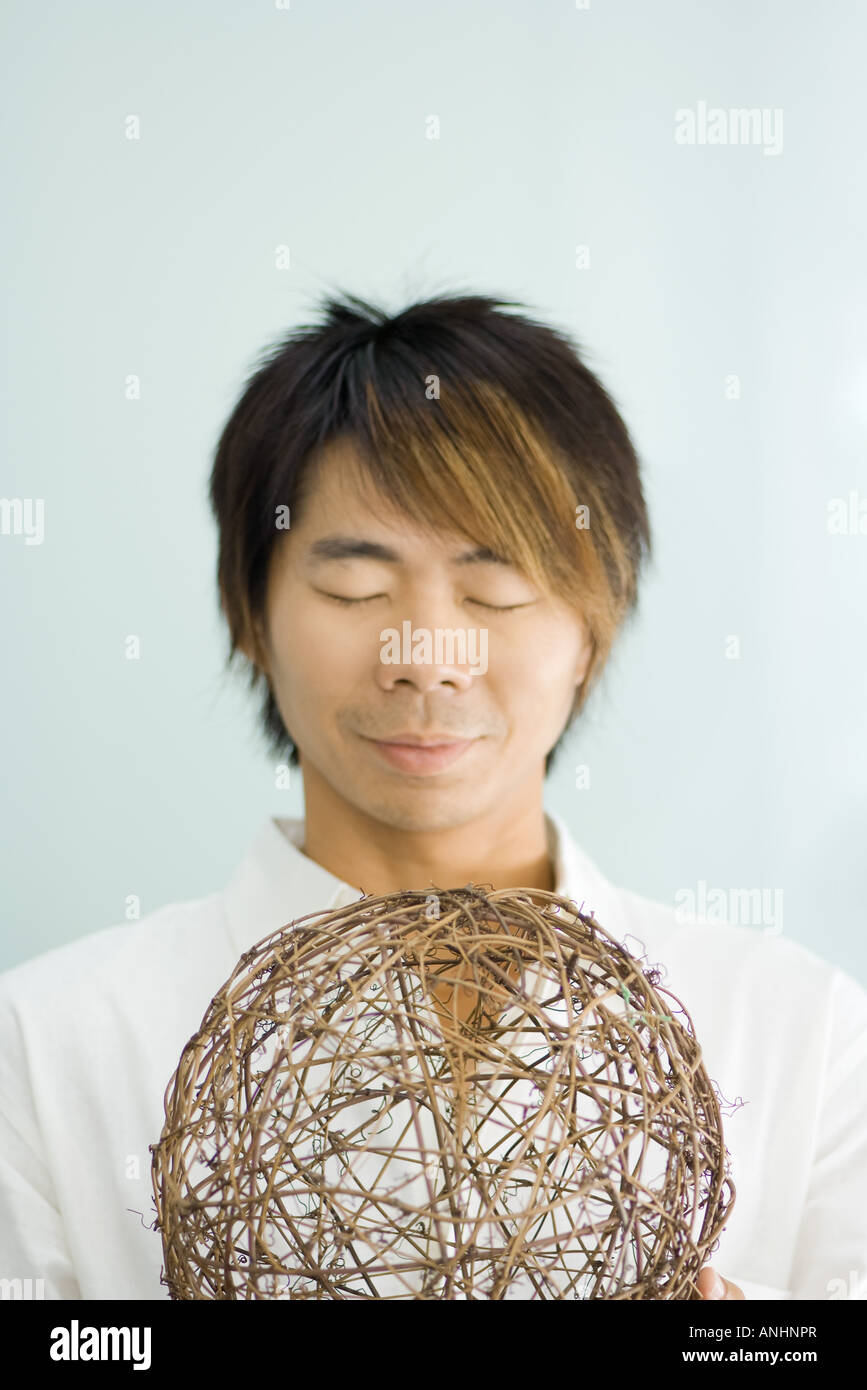 Man holding sphere, eyes closed Stock Photo - Alamy