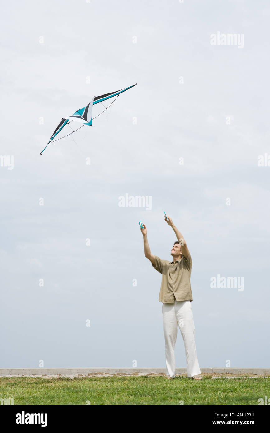Man flying kite, arms raised, full length Stock Photo - Alamy