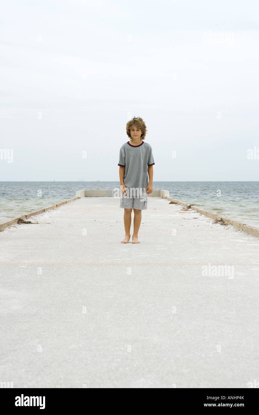 Boy standing on pier, looking at camera Stock Photo - Alamy