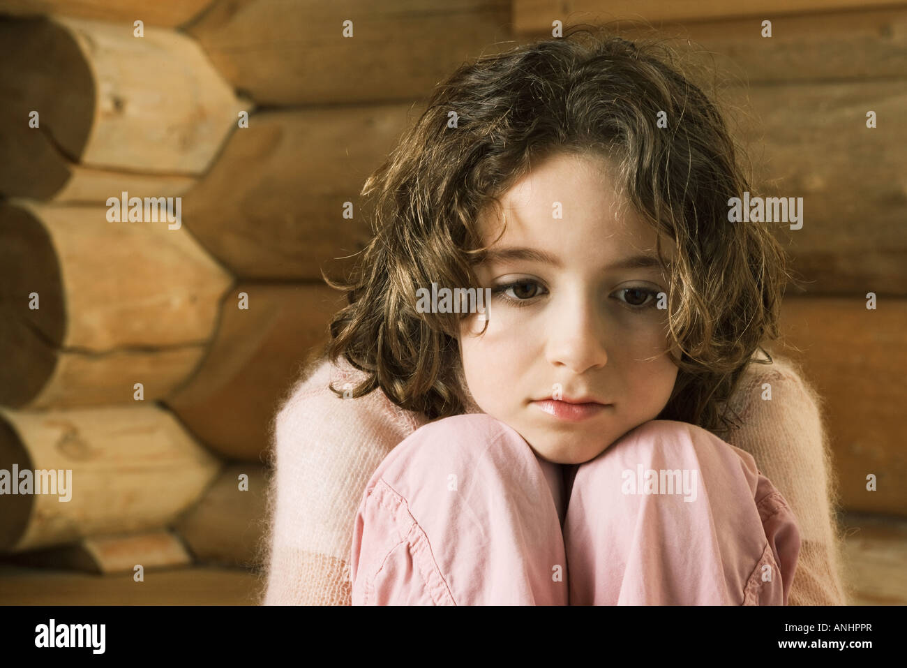 Girl resting head on knees, looking away Stock Photo - Alamy