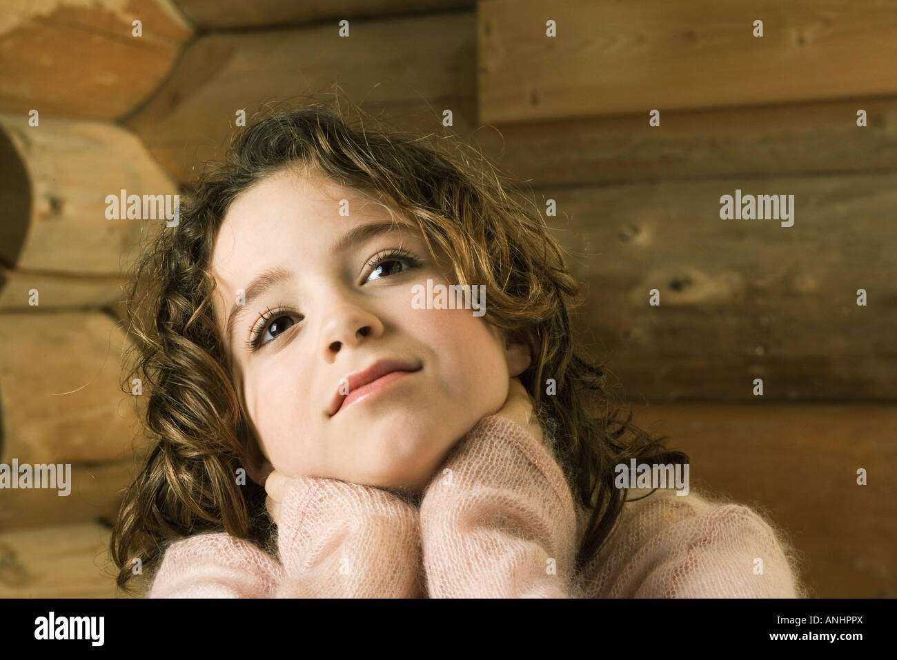 Girl with hands over neck, looking up Stock Photo - Alamy