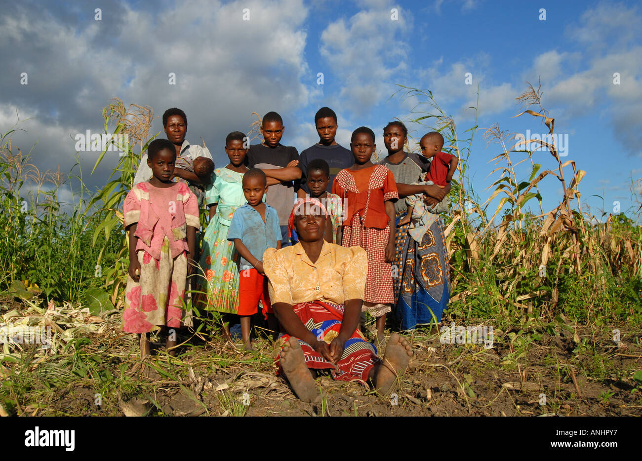 Enelesi Lamusi, a woman farmer, sits on her own land with her children ...