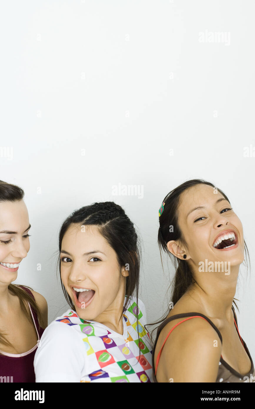 Three young friends smiling together, two looking at camera Stock Photo ...