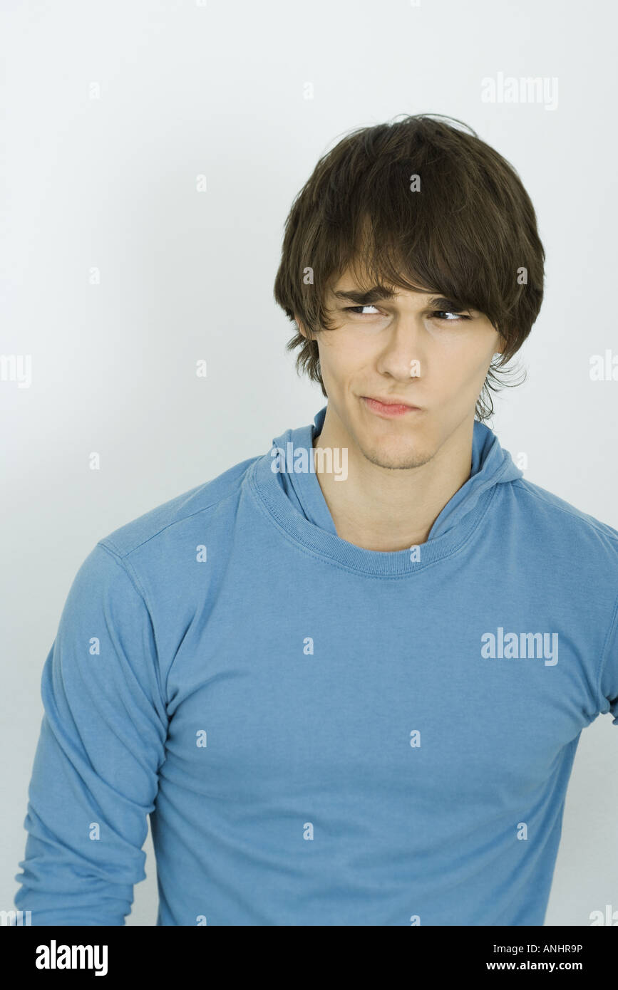 Young man furrowing brow, looking away Stock Photo - Alamy