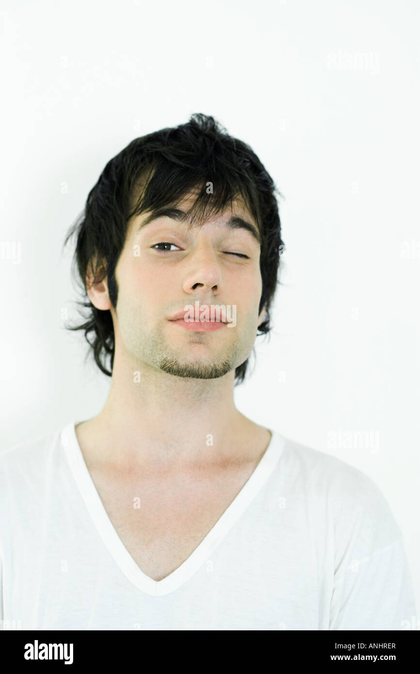 Young man with goatee winking at camera, portrait Stock Photo - Alamy