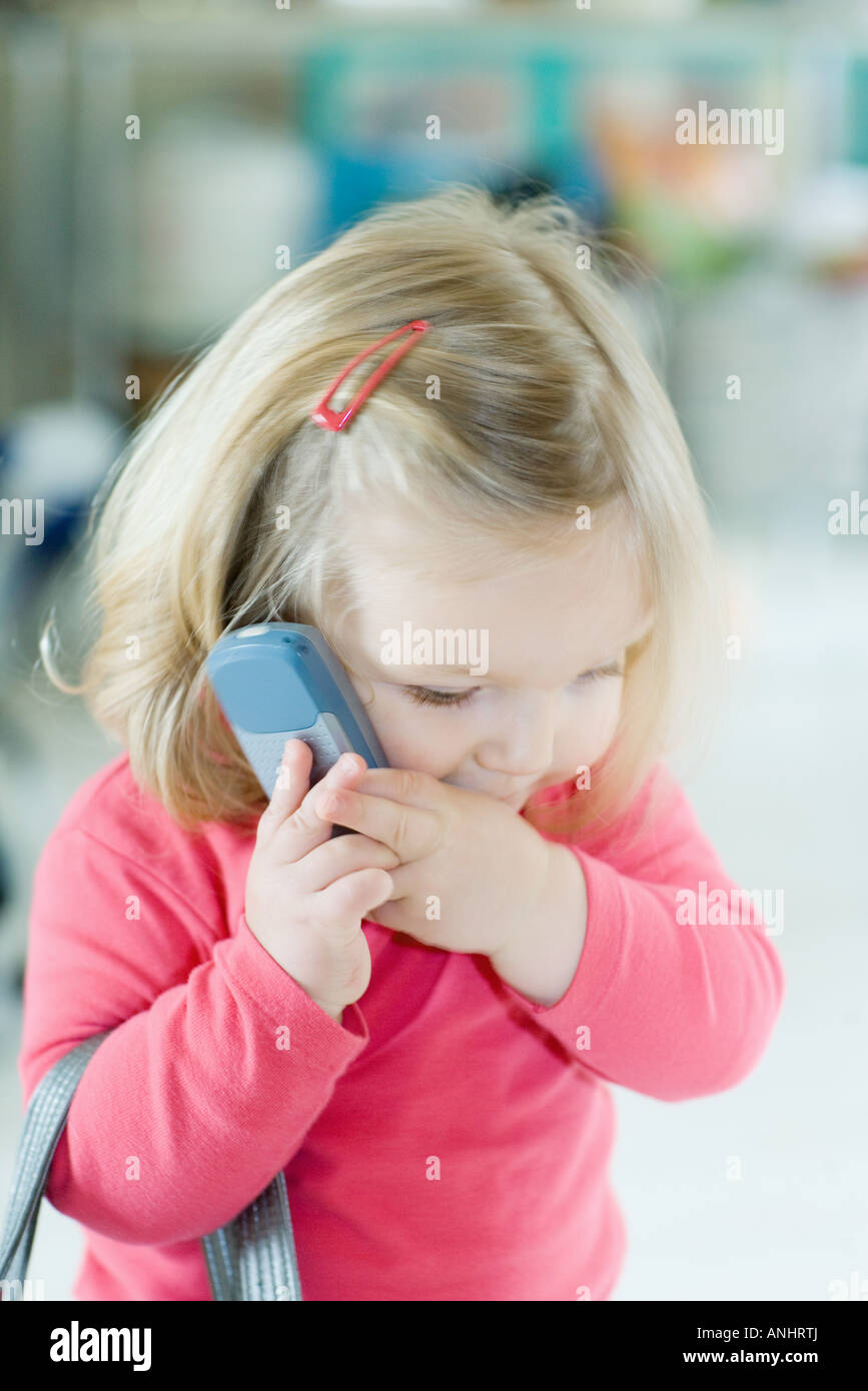 Blonde toddler girl holding cell phone to ear Stock Photo - Alamy