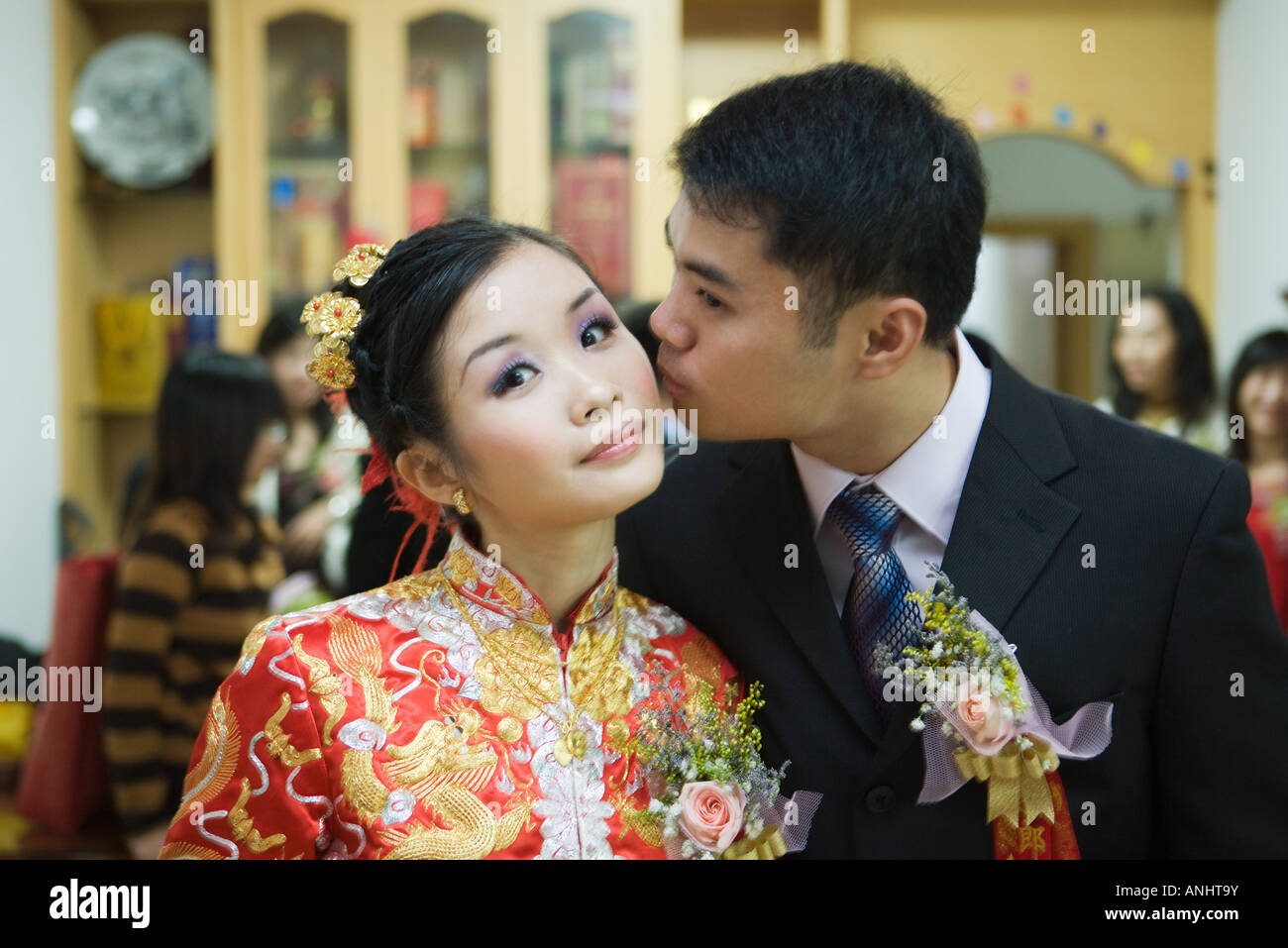 Bride dressed in traditional Chinese clothing, looking at camera as ...