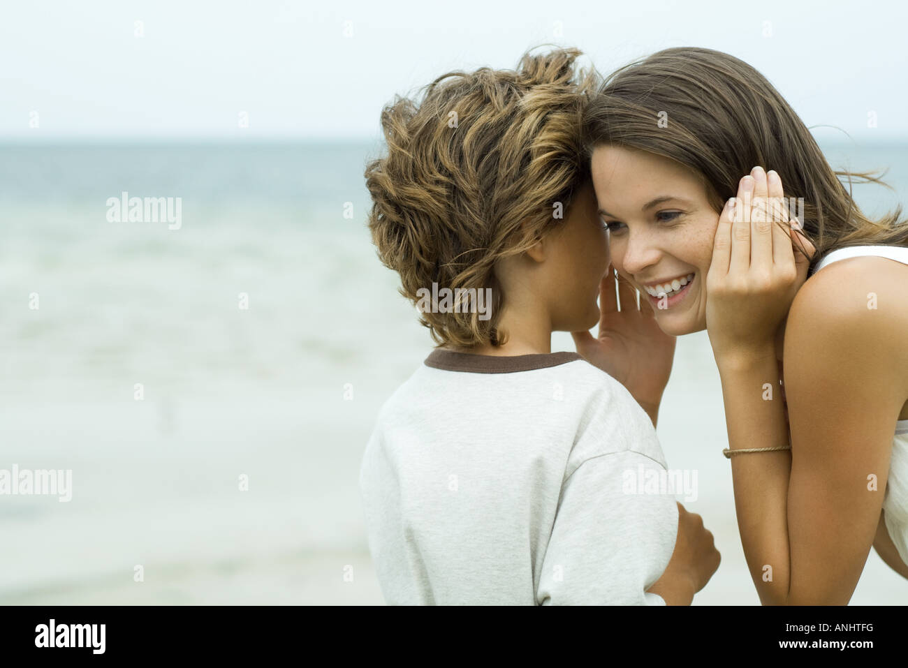 Boy whispering in teen sister's ear, close-up Stock Photo - Alamy