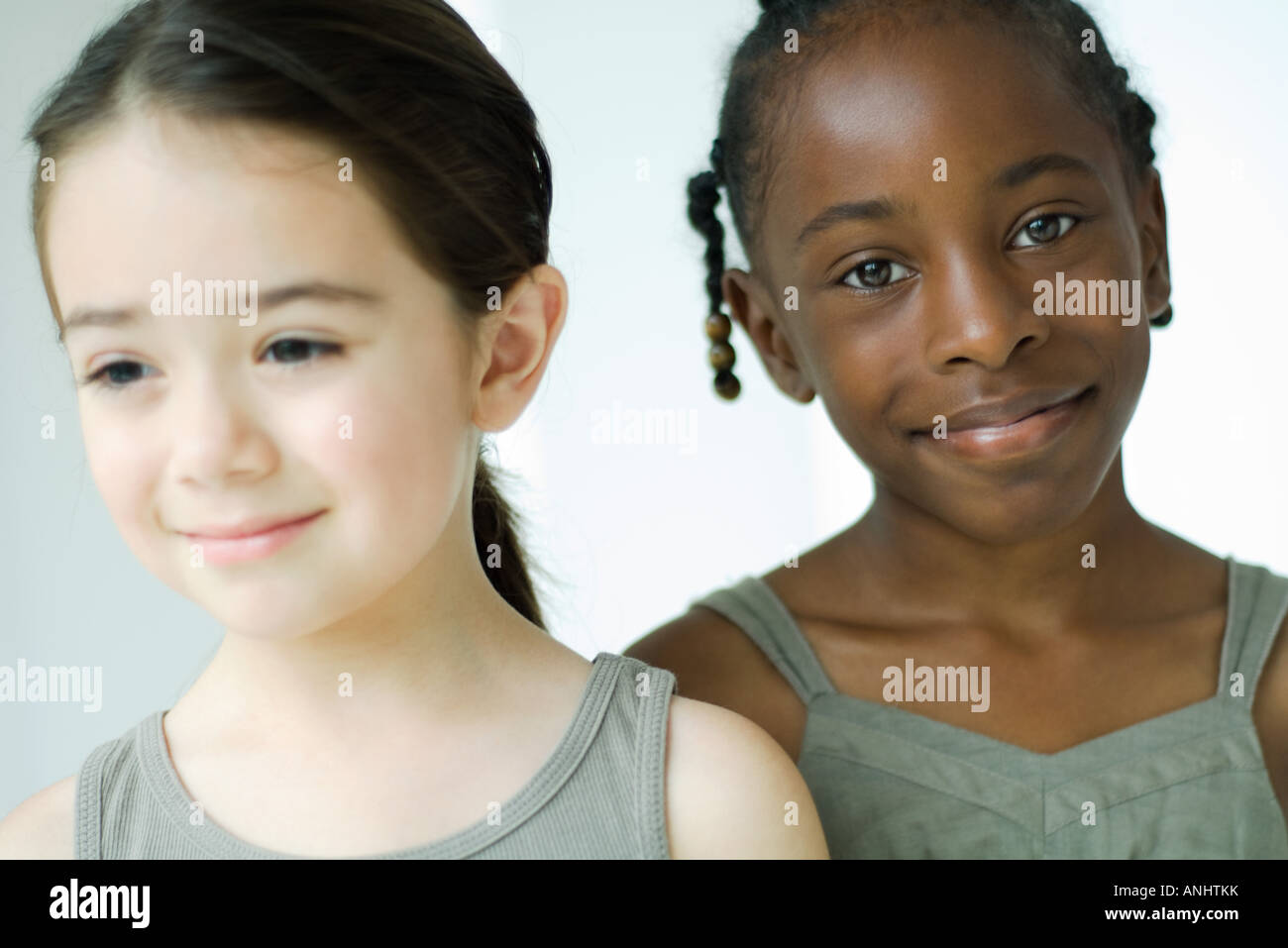 Two girls smiling, one looking at camera Stock Photo - Alamy