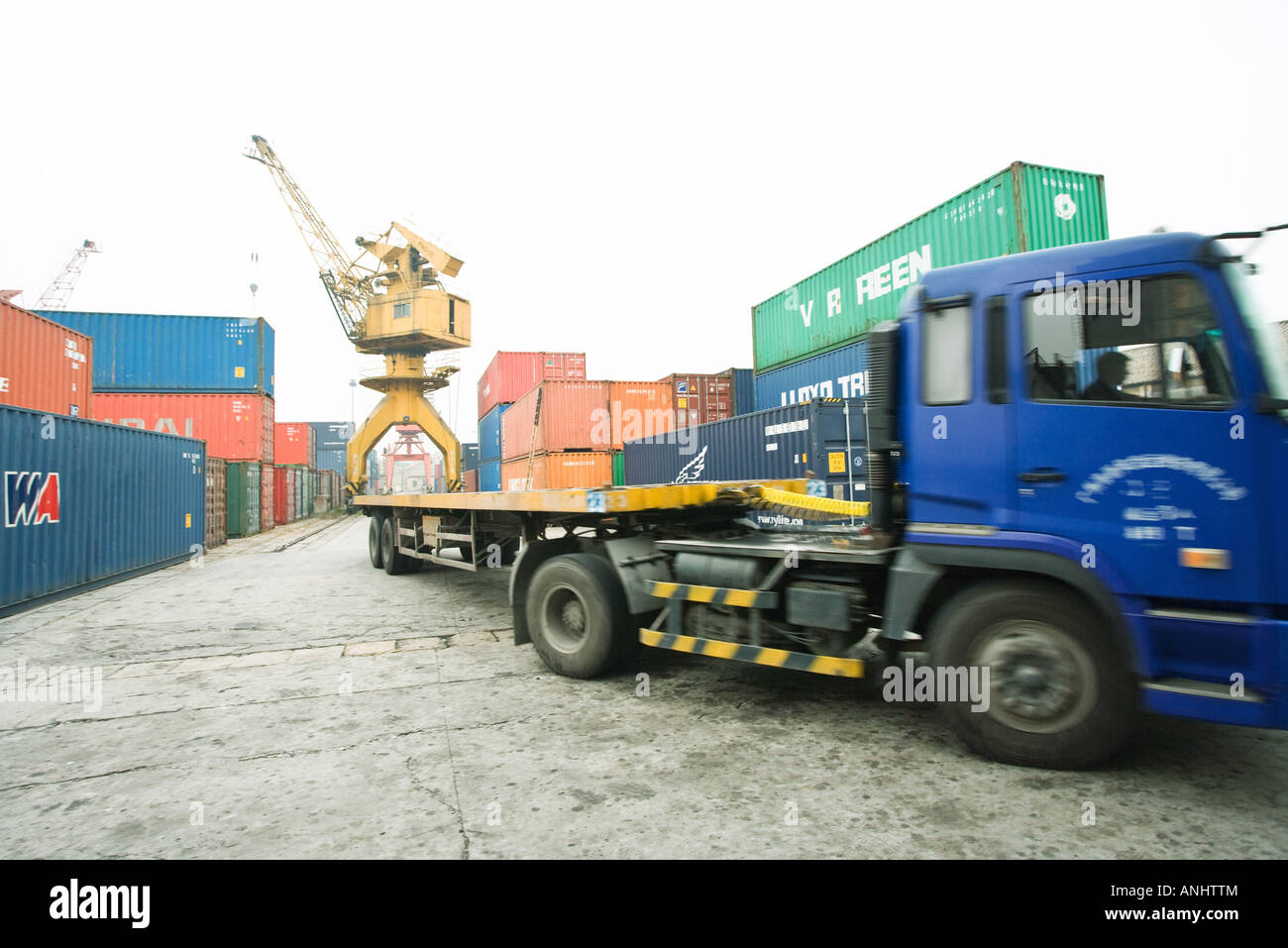 Truck driving through cargo containers Stock Photo - Alamy
