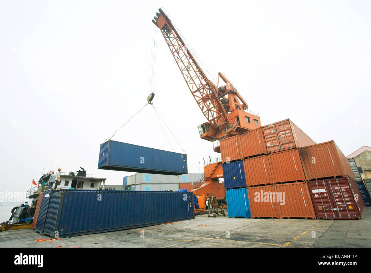 Crane picking up cargo container Stock Photo - Alamy
