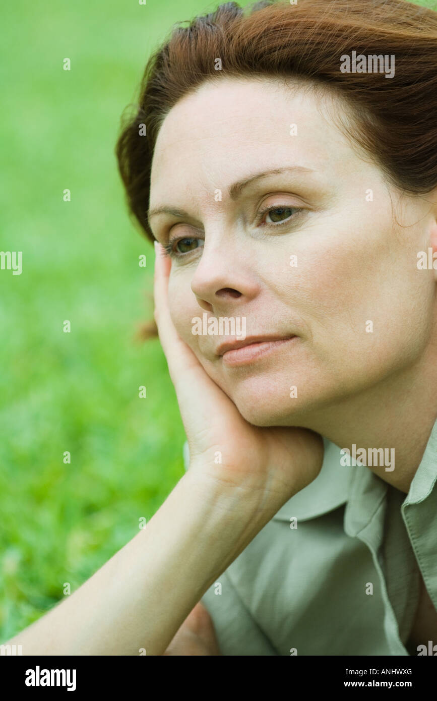 Mature woman leaning on hand, looking away, portrait Stock Photo - Alamy