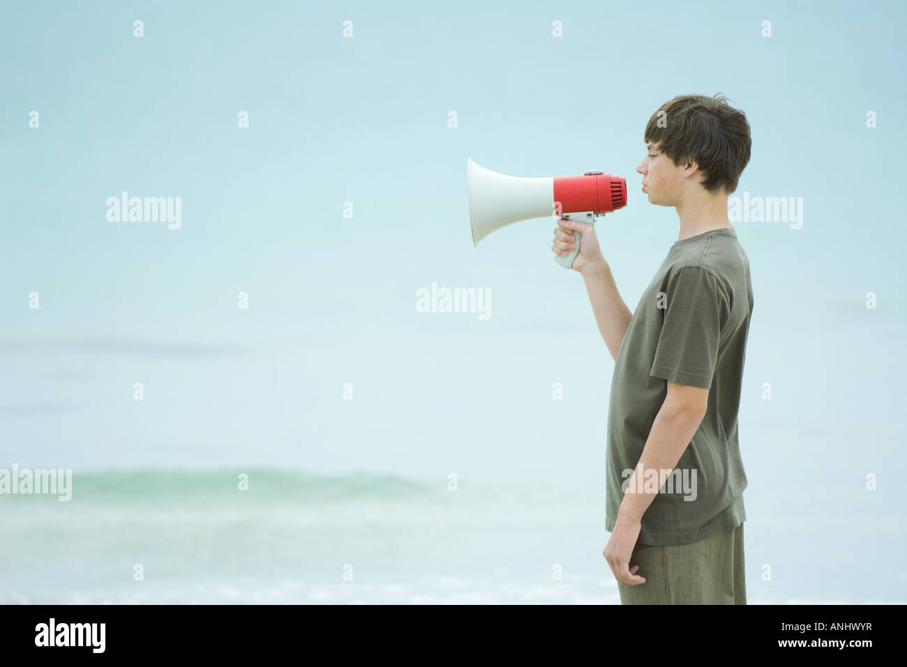 Boy using megaphone, side view Stock Photo - Alamy