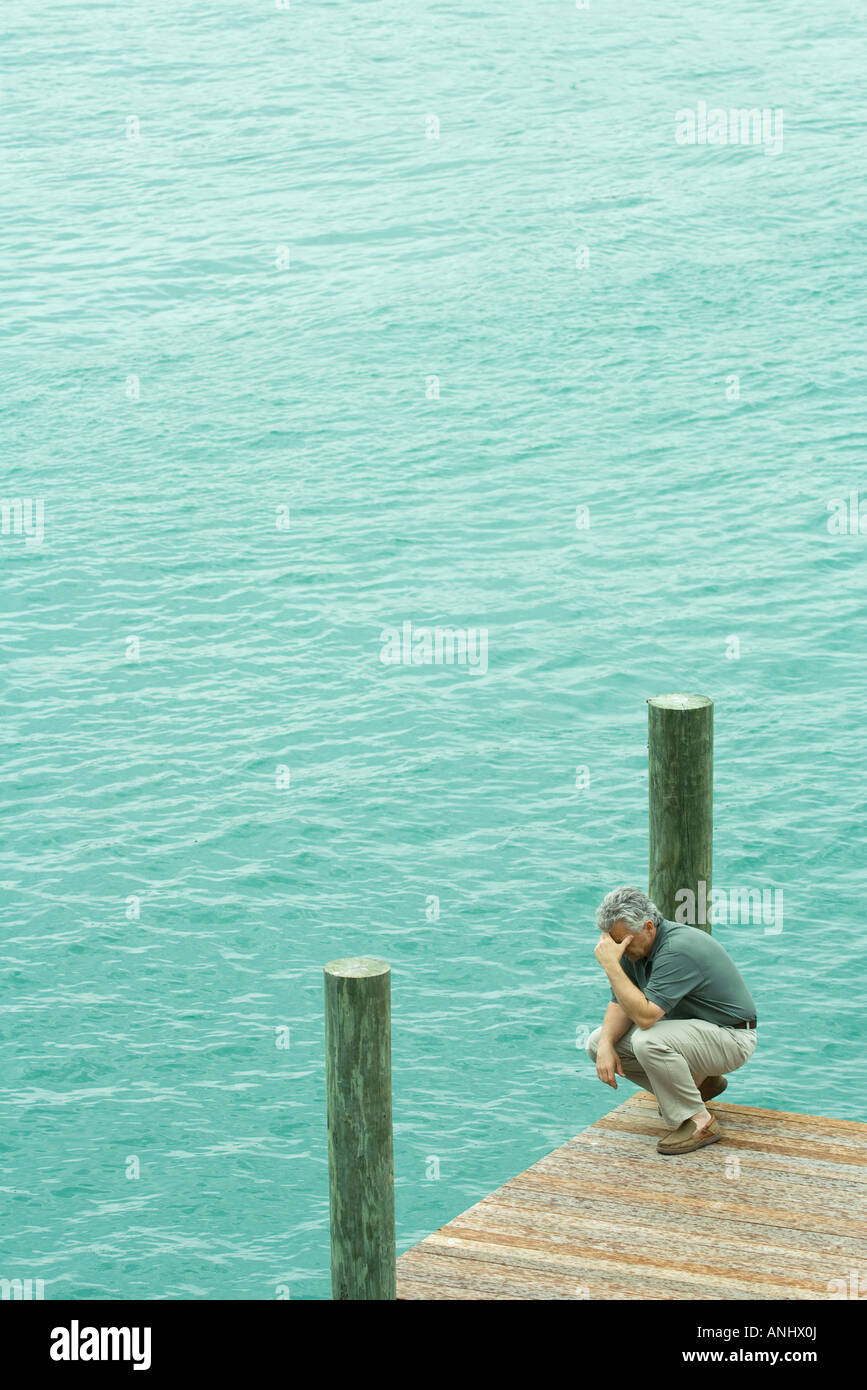 Man crouching head down hands hi-res stock photography and images - Alamy