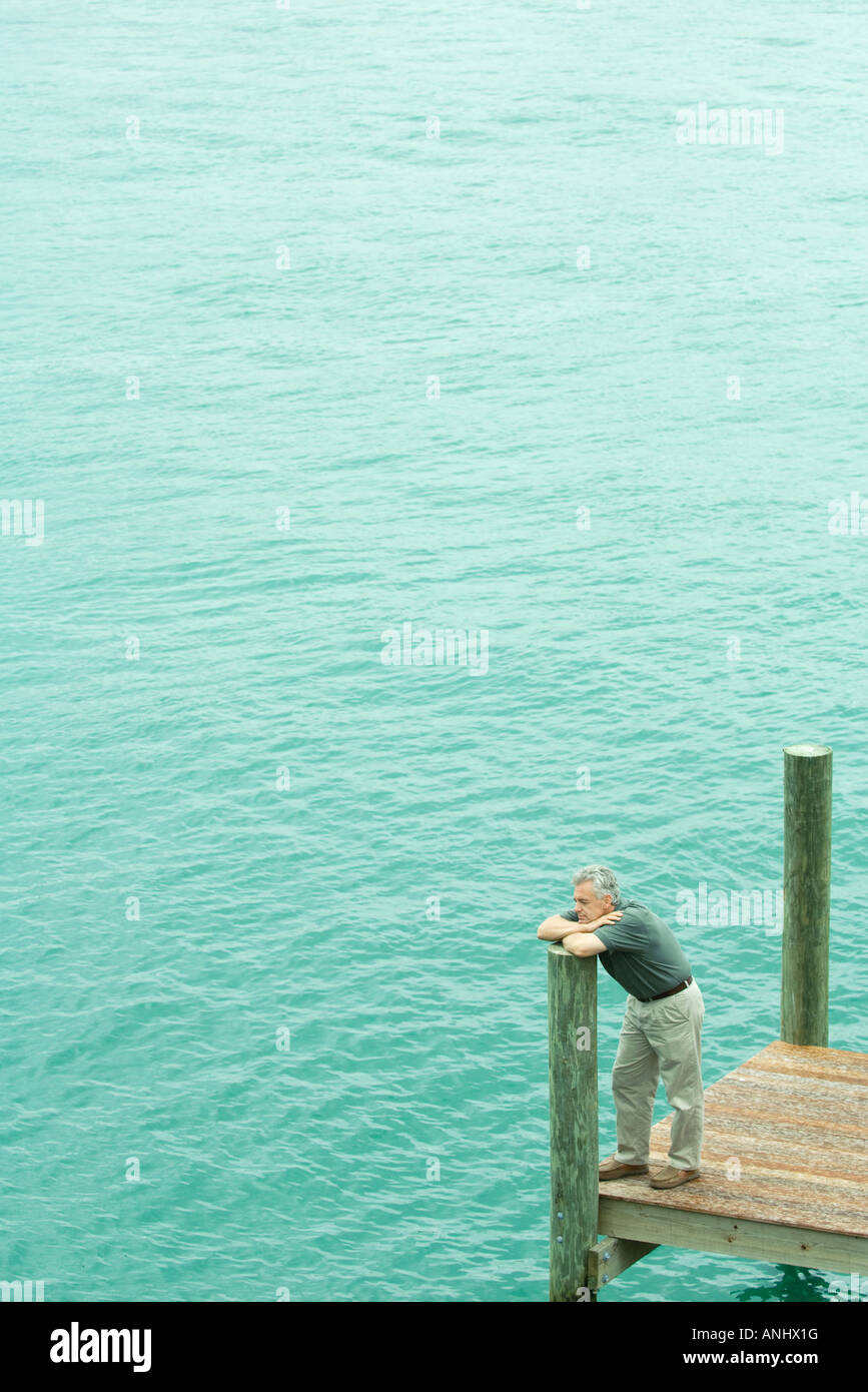 Man standing on dock, leaning on post, high angle view Stock Photo - Alamy