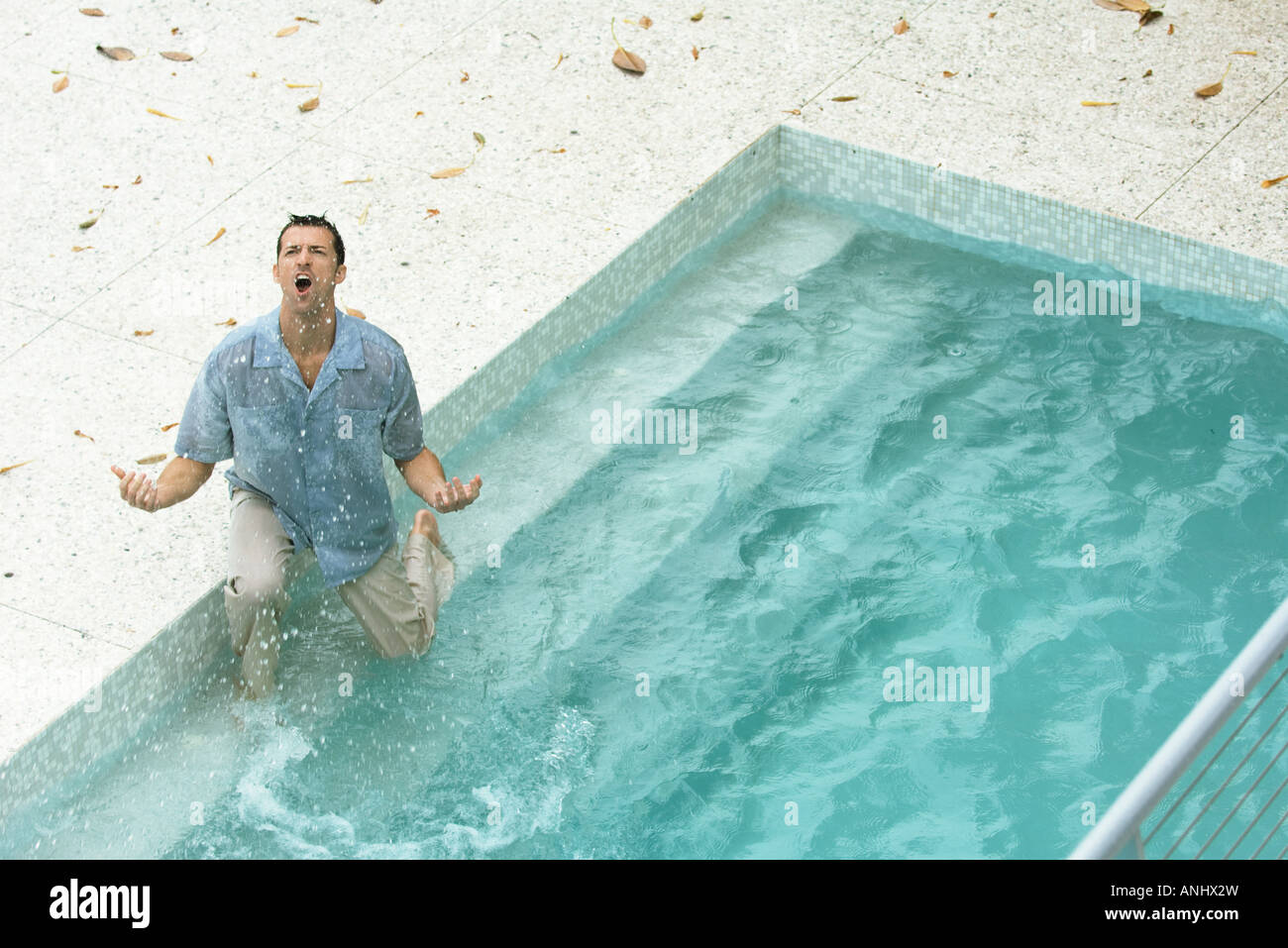 Man splashing in pool, fully clothed, shouting and gesticulating, high ...