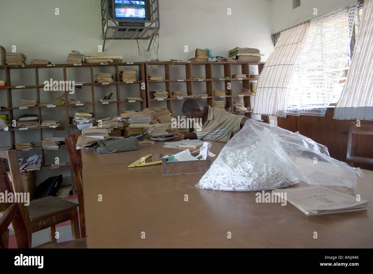 Teacher marking exercise books in the staffroom of a secondary school ...