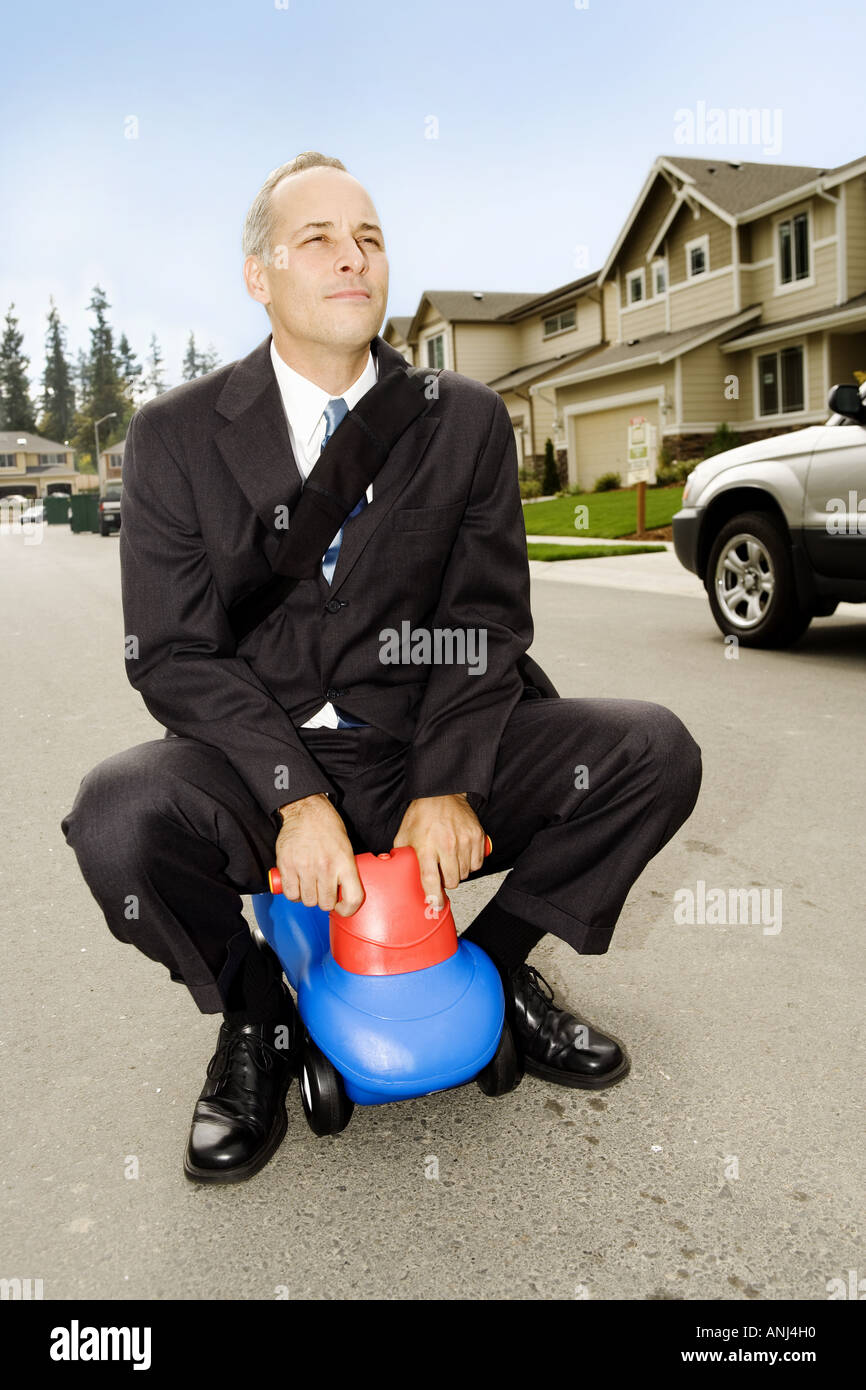 Businessman driving a toy car Stock Photo - Alamy