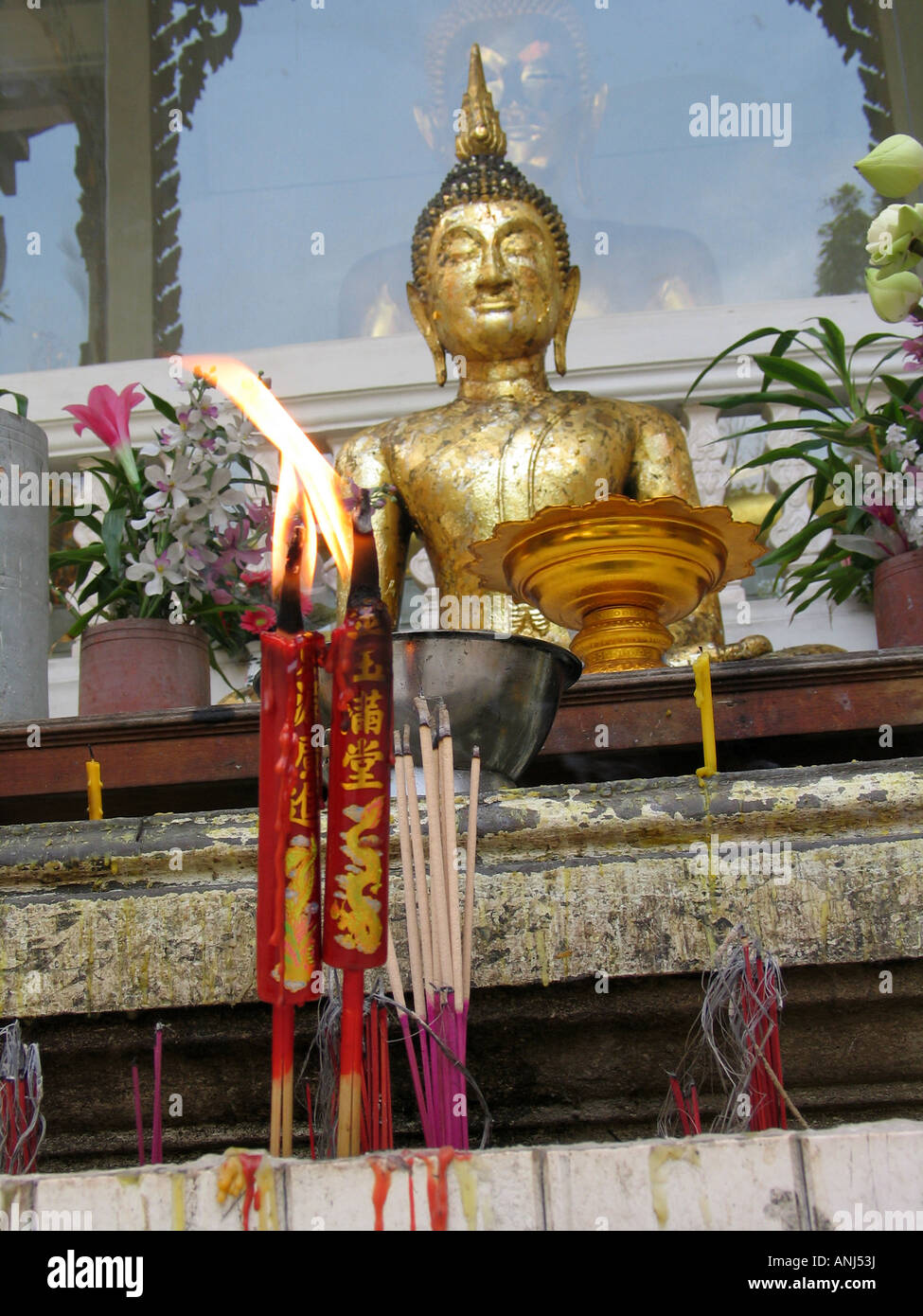 Candles, incense and Buddhist statue at a temple in Bangkok, Thailand ...