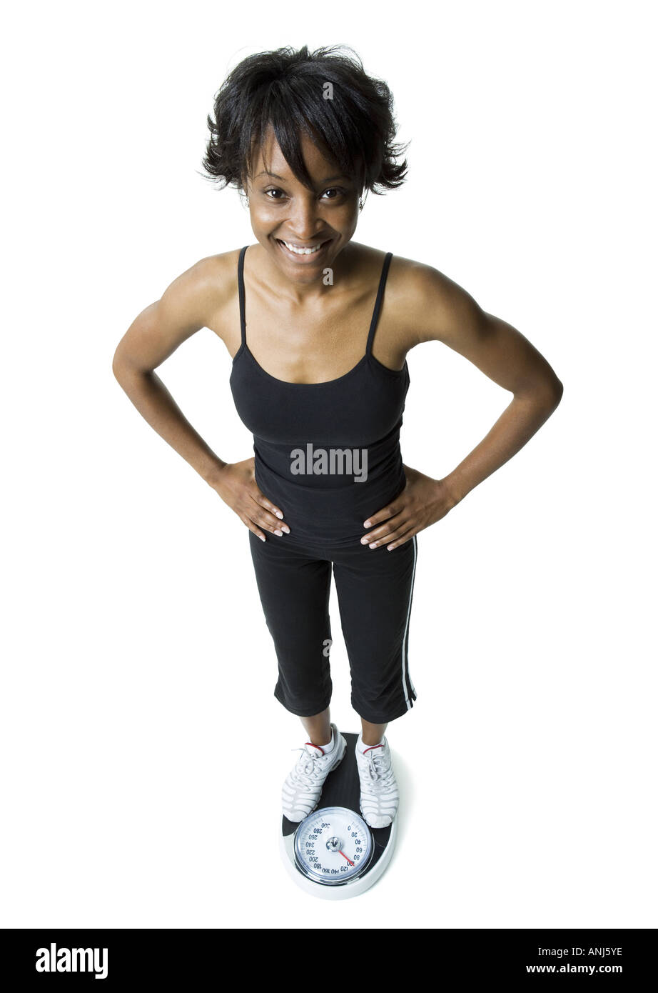 Portrait of a young woman standing on a scale Stock Photo - Alamy