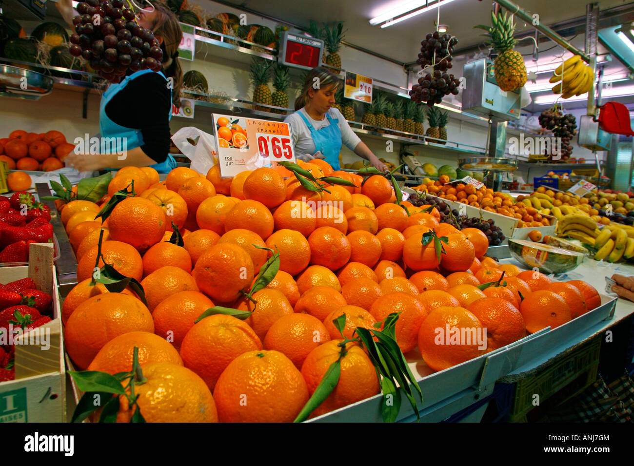 Customer buying in a stall with fruit, vegetable, oranges and ...