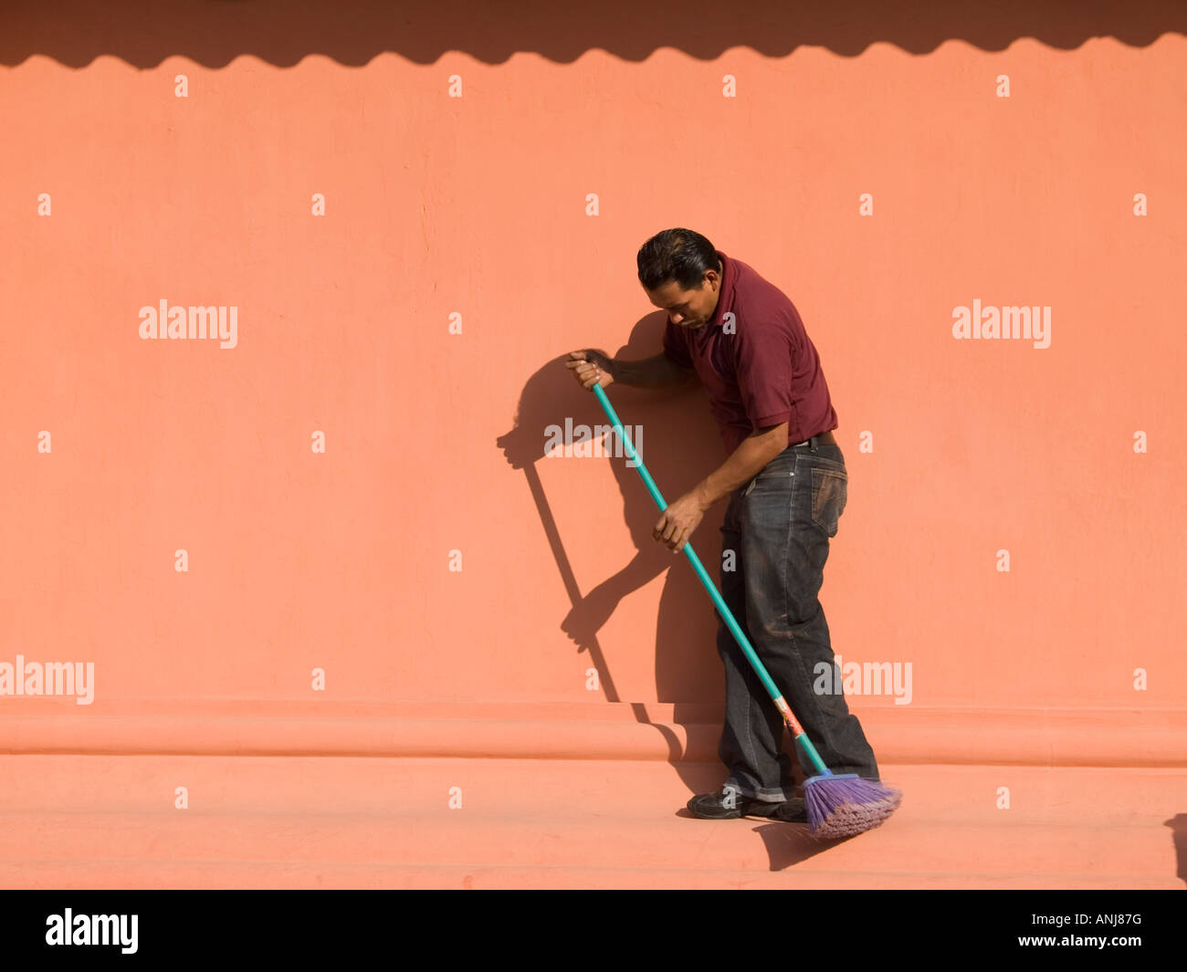 Worker sweeps the exterior ledge of a colonial style building Stock ...