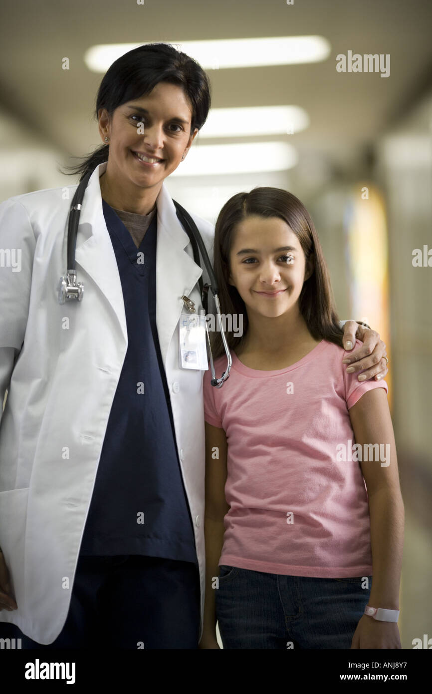 Portrait of a female doctor standing with a young female patient Stock ...