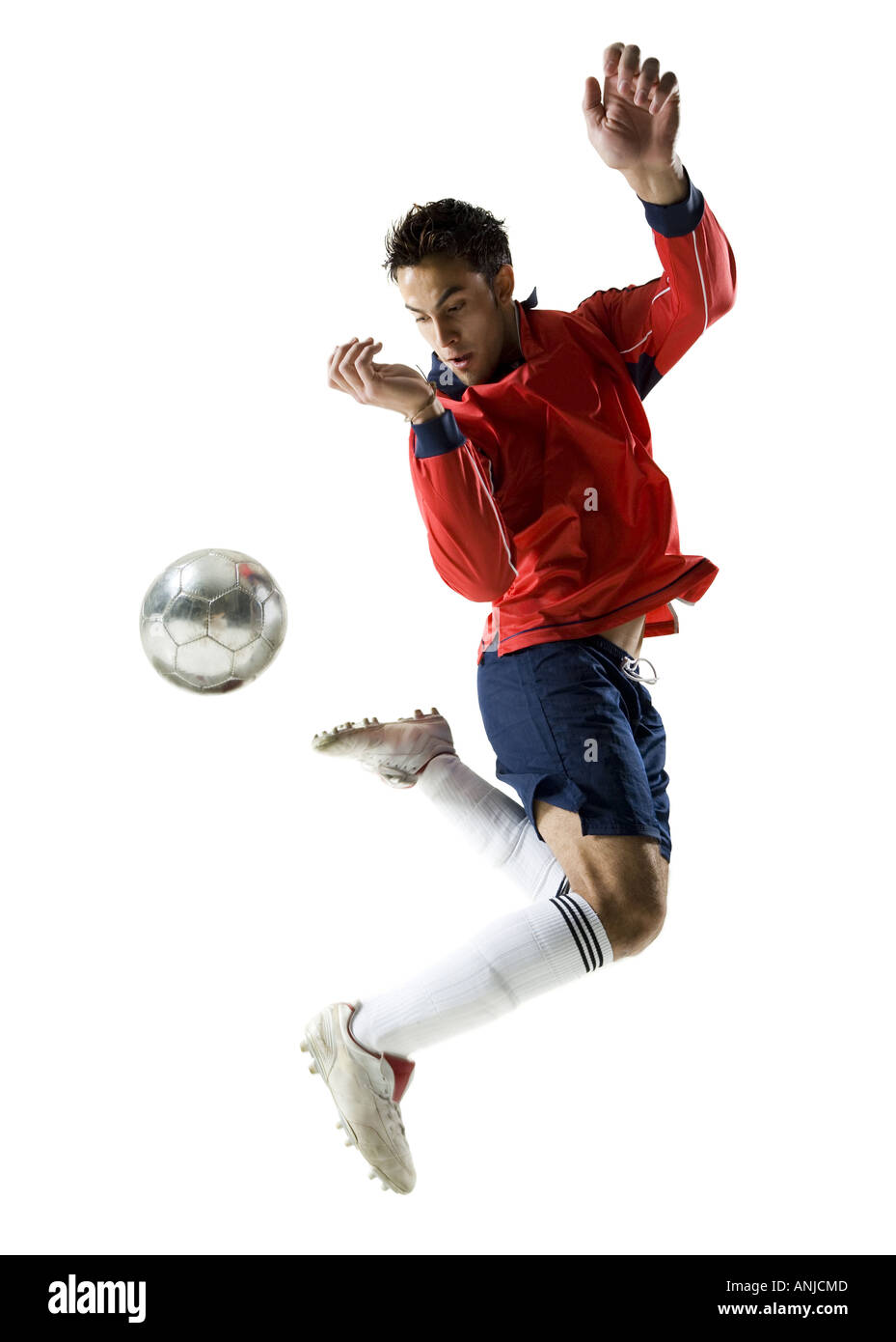 Young man kicking a soccer ball Stock Photo - Alamy