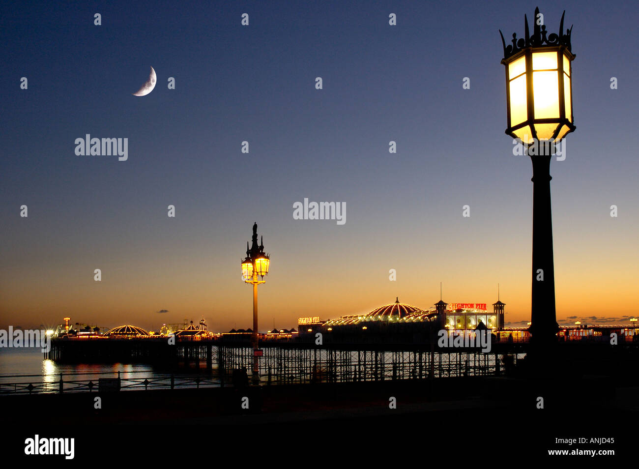 Brighton Pier at night with crescent moon Brighton East Sussex England ...